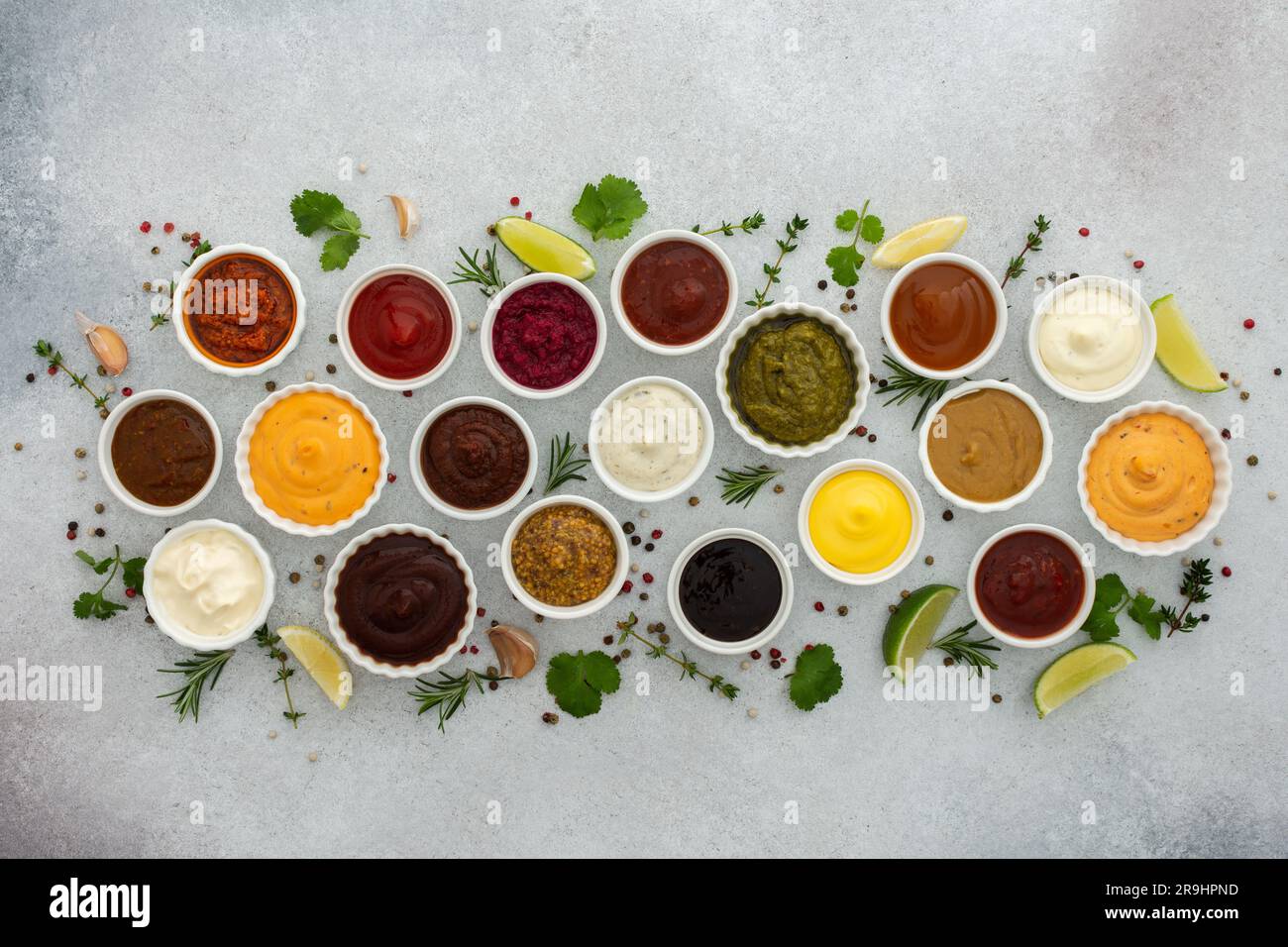 Different types of sauces in bowls with seasonings, rosemary and pepper ...