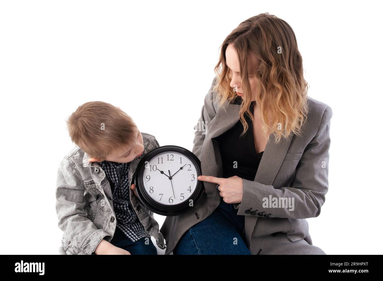 Schoolboy mom and son are studying the clock. Isolated over white ...