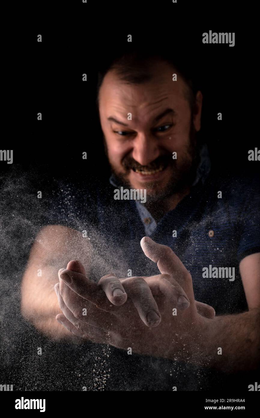 The man claps his hands emotionally with anguish. A cloud of flour ...