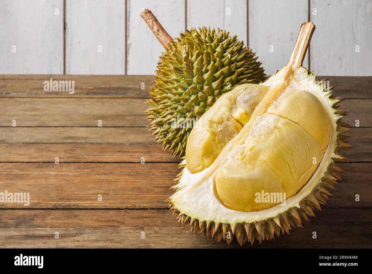 Durian fruit cut in half on a wooden table. The durian is the edible ...