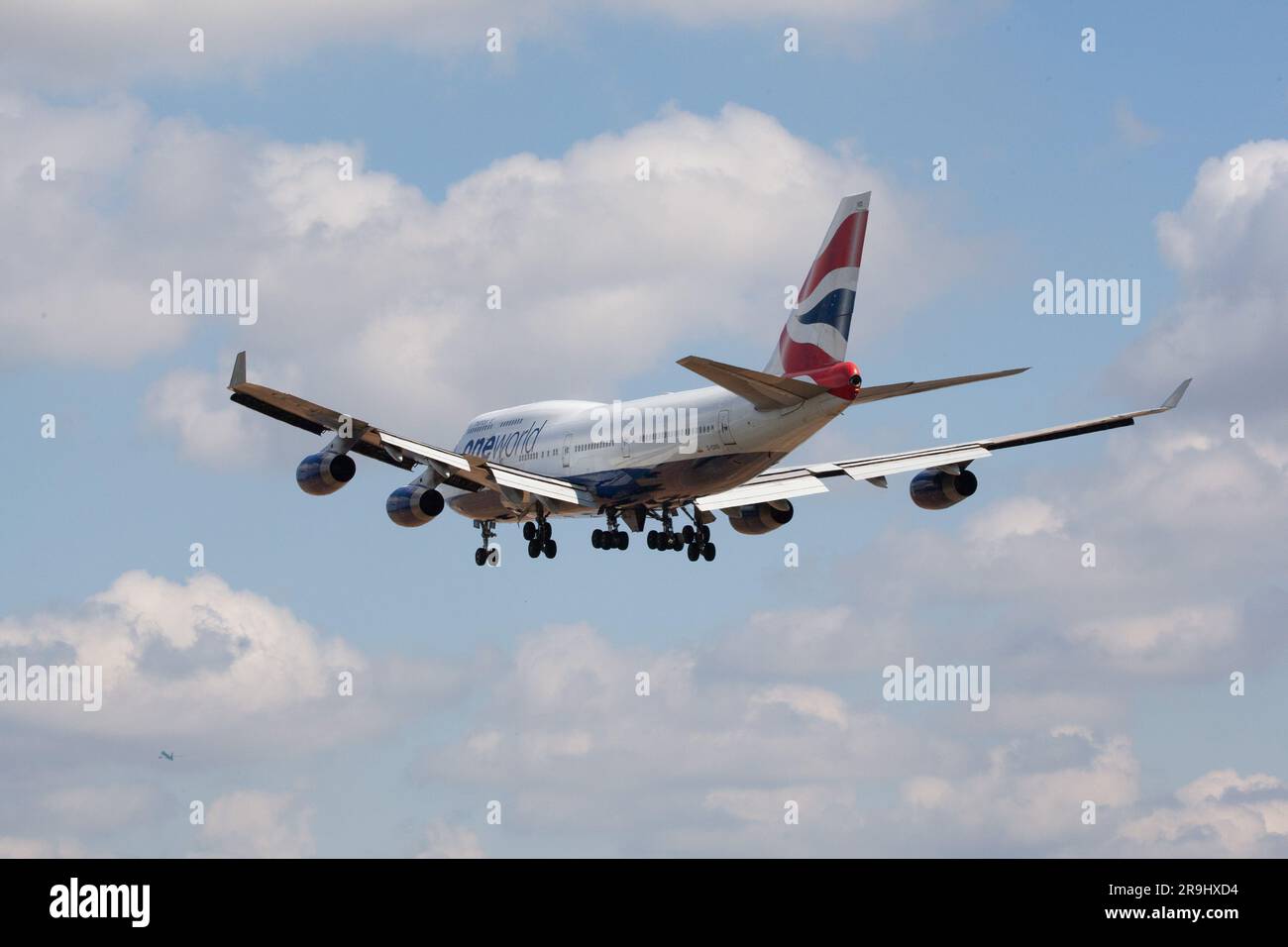 An airplane soaring through the blue sky with fluffy white clouds in ...