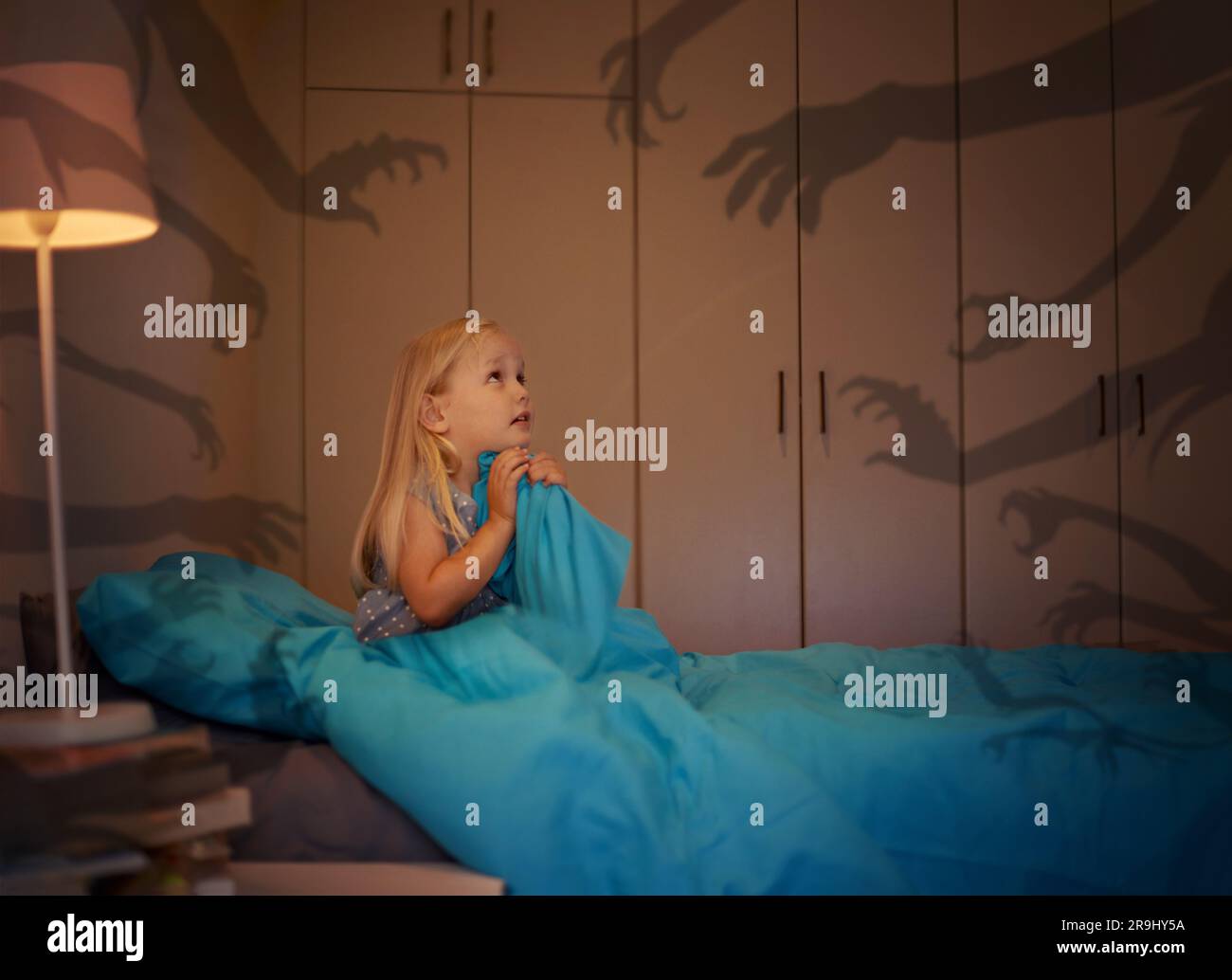 Fear, shadow and monster with a girl in bed at night feeling afraid or ...