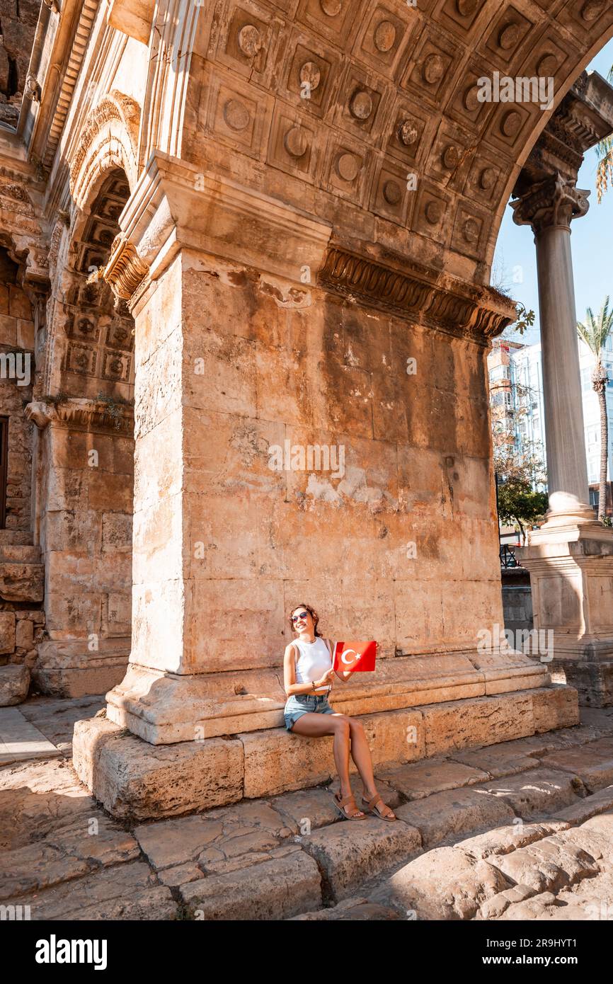 Happy traveller girl with turkish flag in hand and famous gate or ...