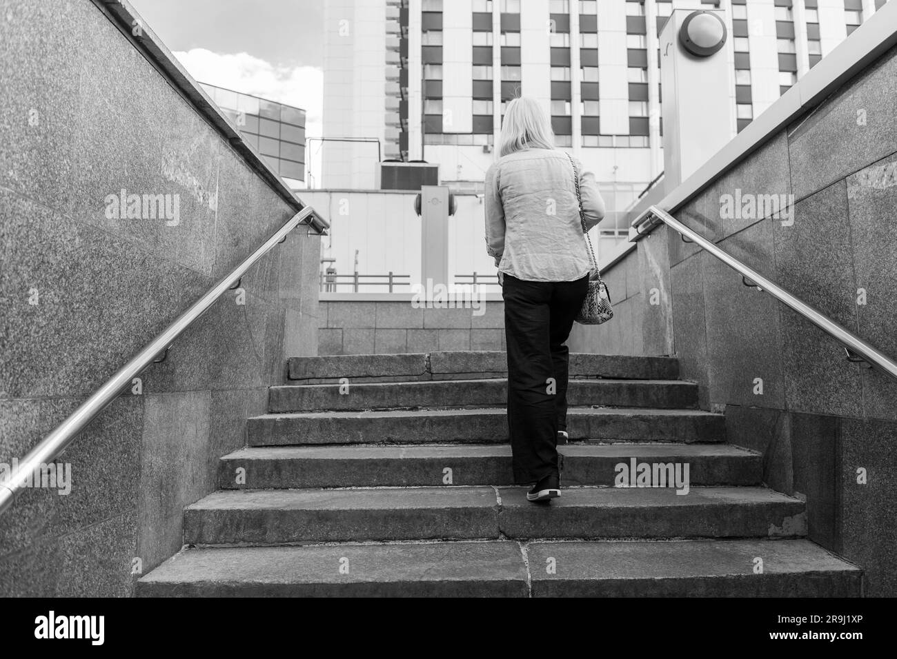 woman climbs the stone stairs in the city. girl going up the stairs ...