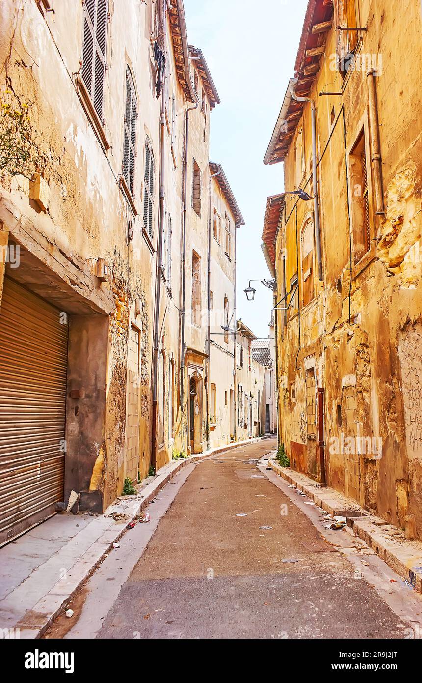The narrow shabby street with abandoned houses, and crumbling plaster ...