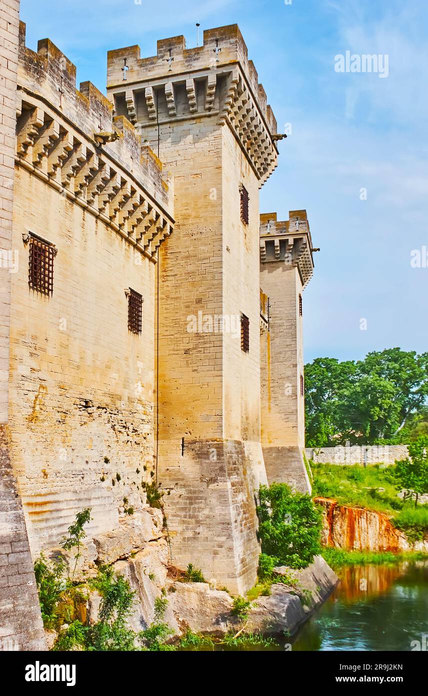 The towers and massive walls of Tarascon Castle with the moat around it ...