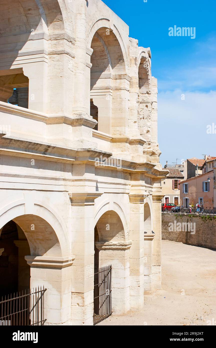 Walk along the old stone wall of the Amphitheatre of Arles, one of the ...
