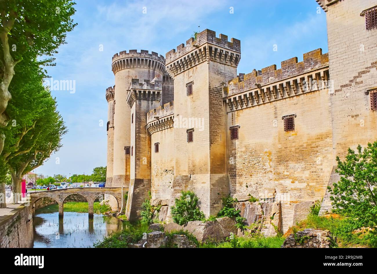 The medieval Tarascon Castle of King Rene with a moat, arched bridge ...