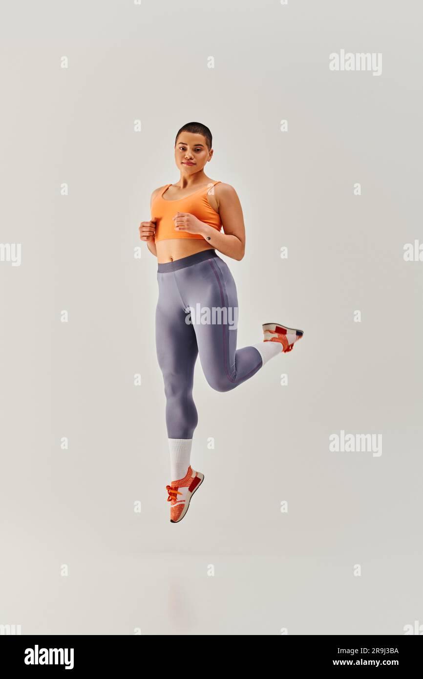 Woman jumping on grey background hi-res stock photography and images ...