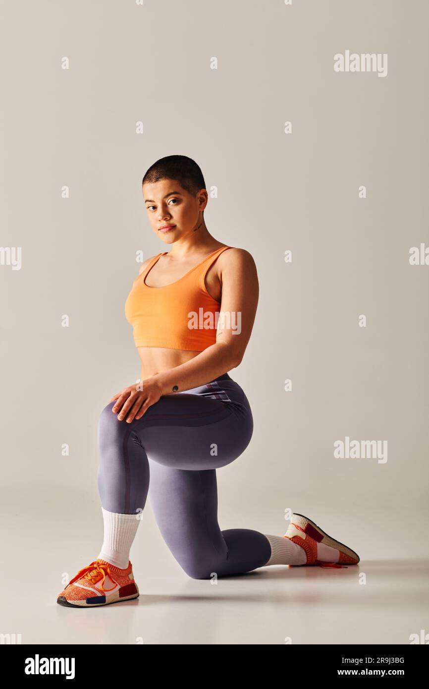 body positivity movement, young short haired woman standing on knee on ...