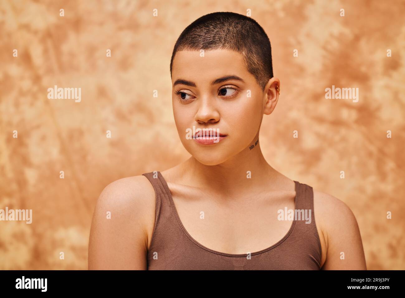 natural beauty, young woman with short hair posing on mottled beige ...