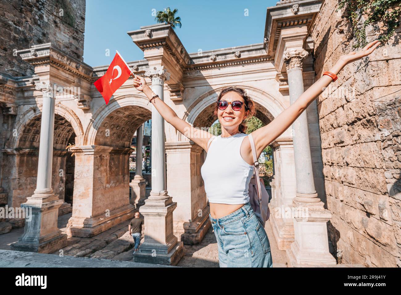 Happy traveller girl with turkish flag in hand and famous gate or ...