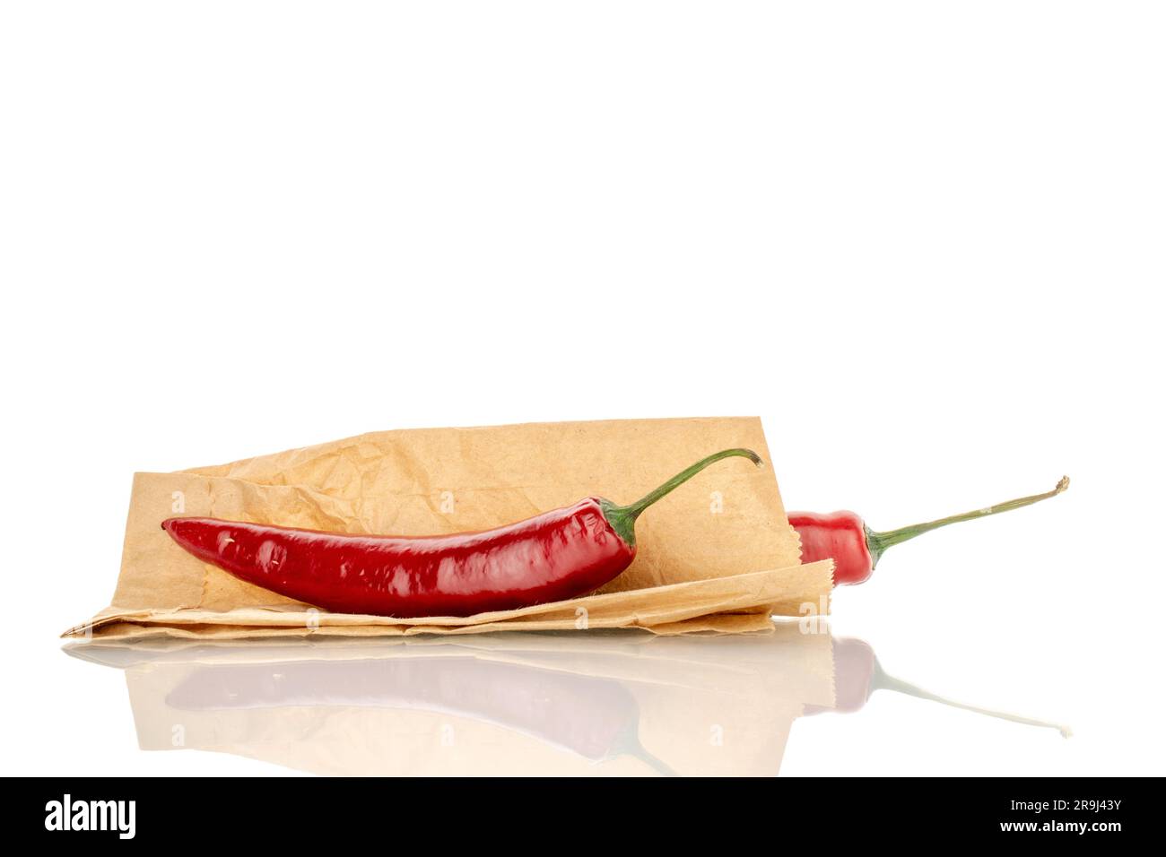 Two pods of hot red pepper with paper bag, macro, isolated on white ...