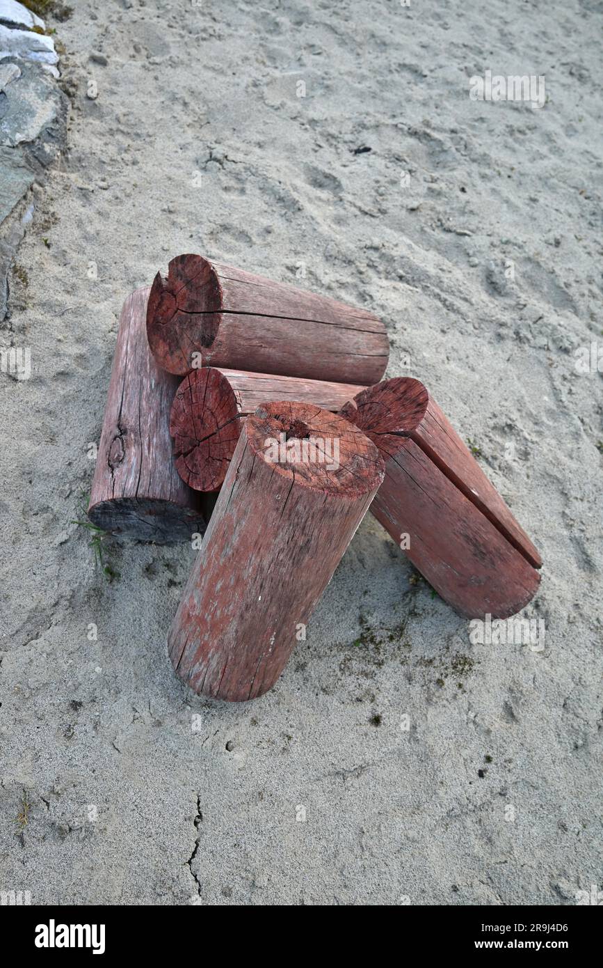 small red logs on the sand Stock Photo - Alamy