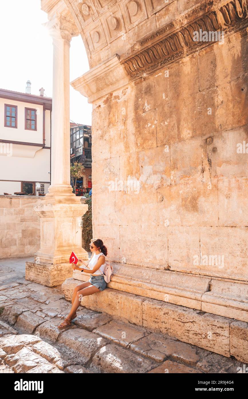 Happy traveller girl with turkish flag in hand and famous gate or ...