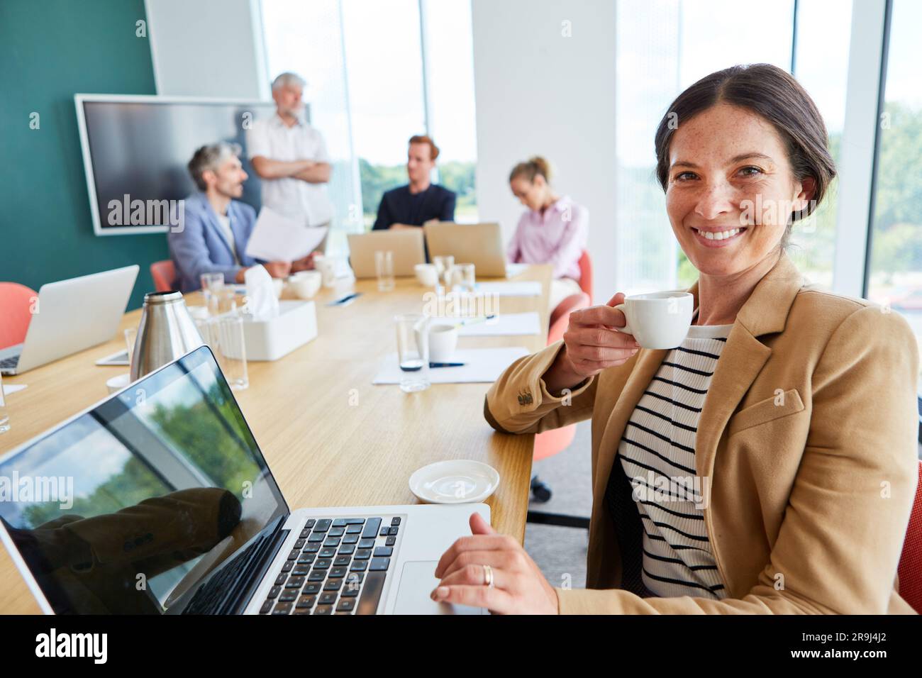 Portrait of smiling businesswoman drinking coffee at workplace Stock ...