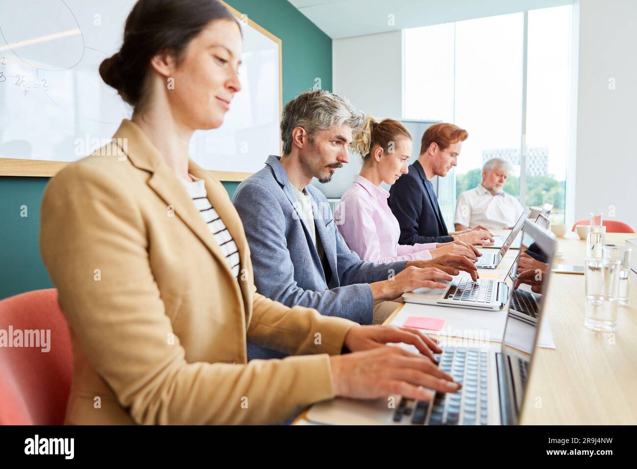 Business team using laptops while working in office Stock Photo - Alamy
