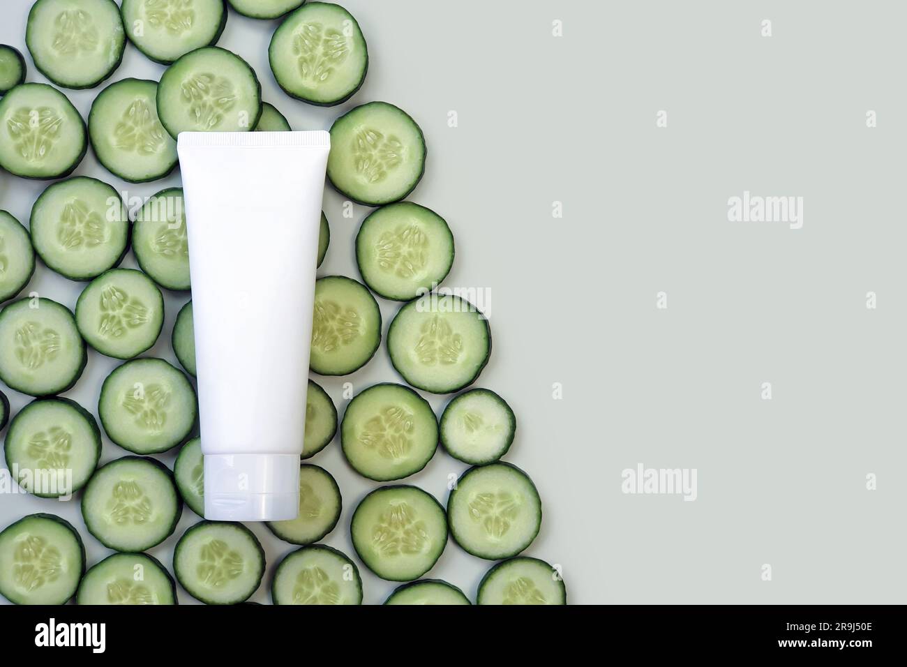 Mockup of white squeeze eco friendly plastic tube and cucumber slices ...