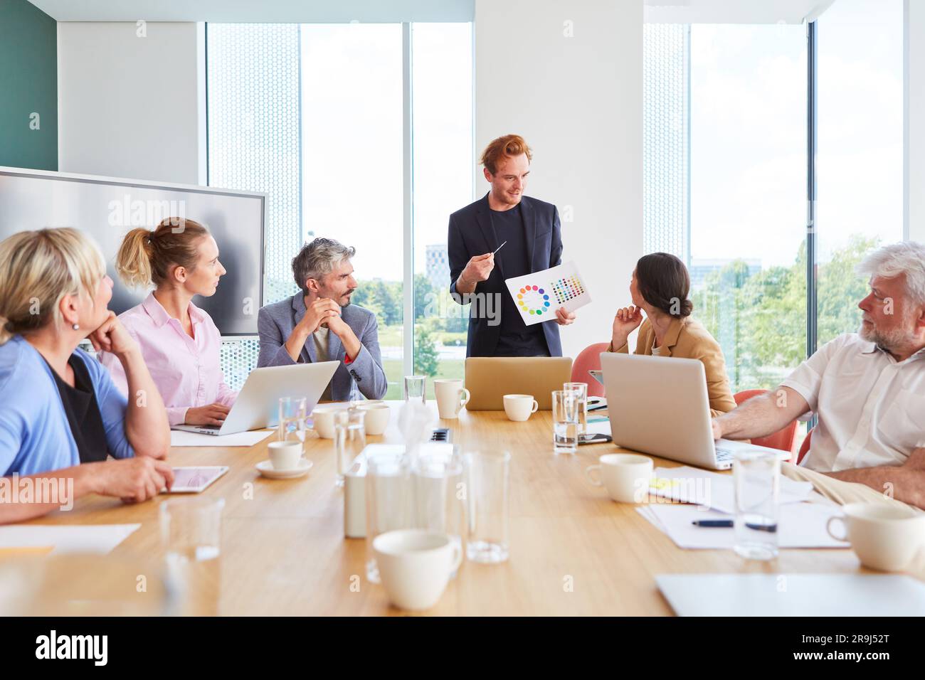 Confident businessman giving presentation through chart in meeting ...