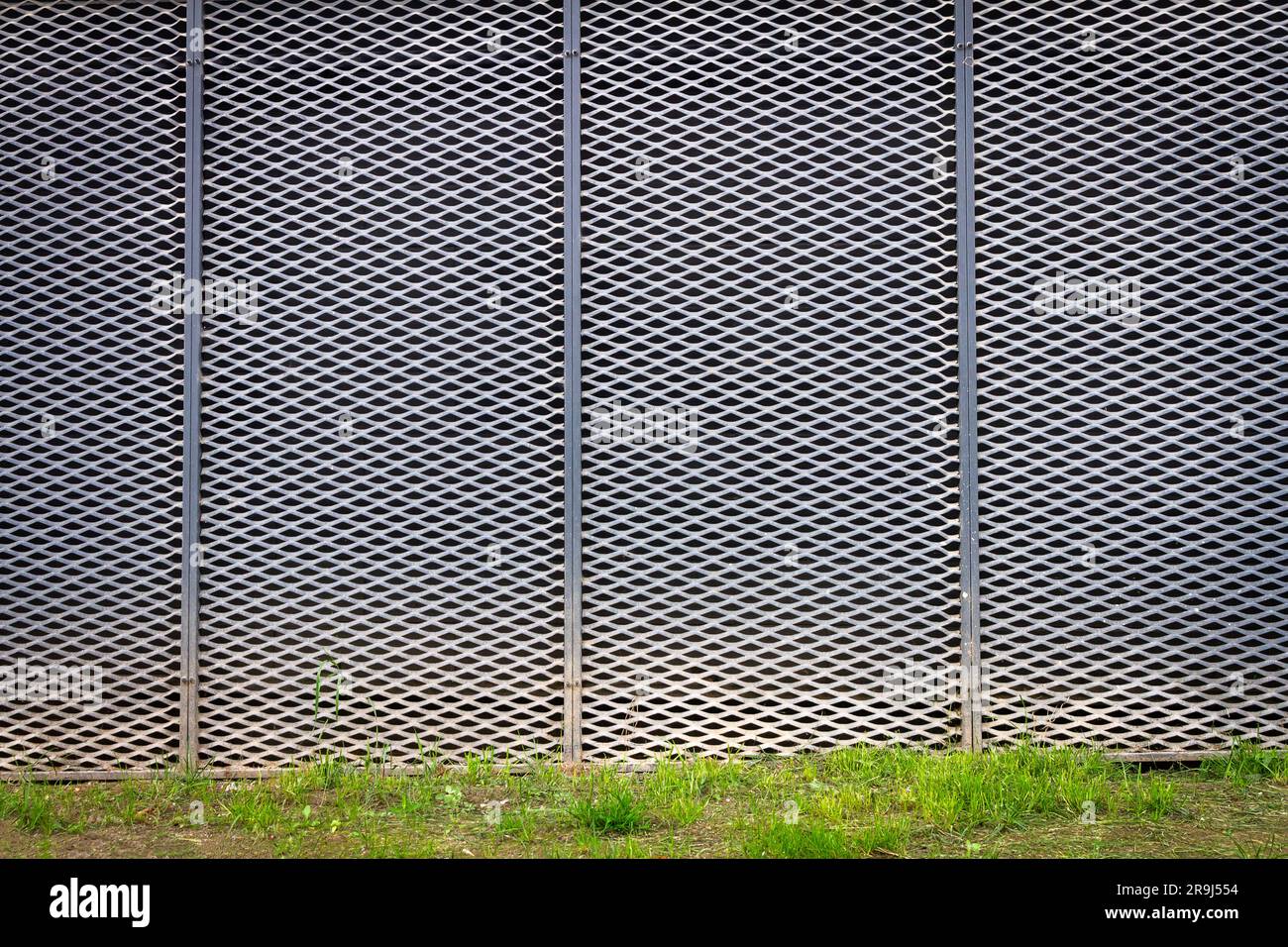 Iron grid wall and green grass. Architecture detail background Stock ...