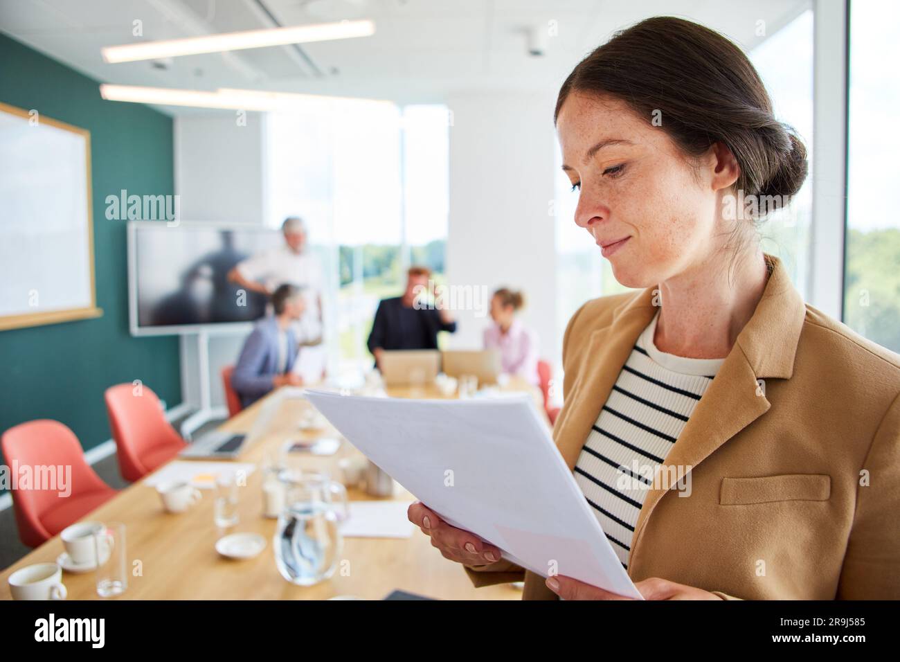 Female professional reading report in conference room at office Stock ...
