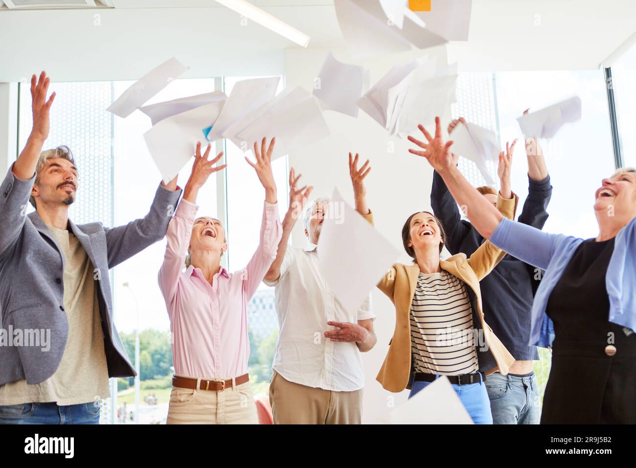 Happy business team cheering and throwing sheets of papers Stock Photo ...