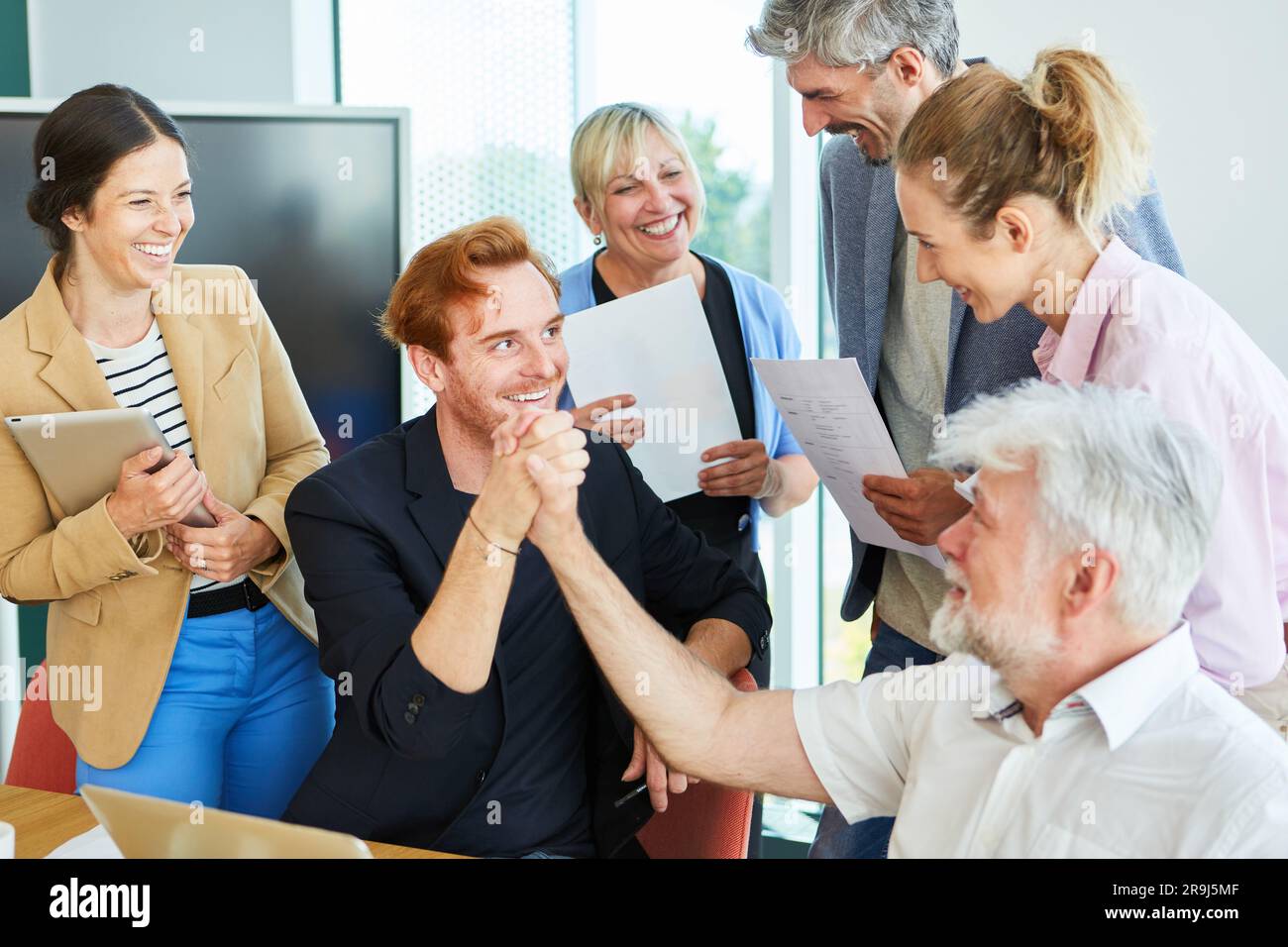 Happy team looking at businessman giving high five to successful ...