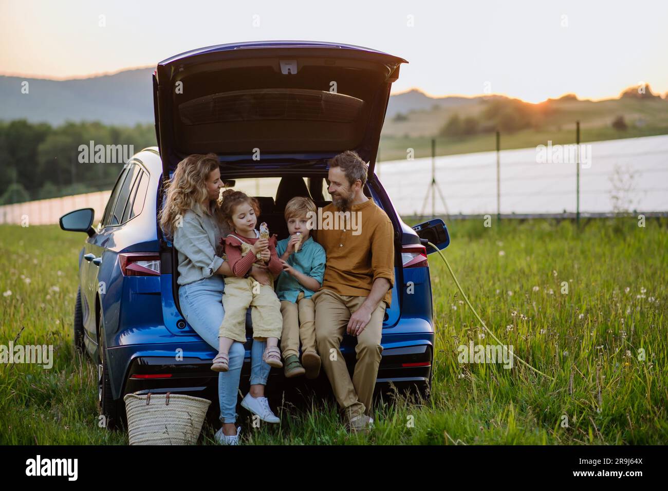 Happy family sitting in a car trunk and waiting for charging Stock ...