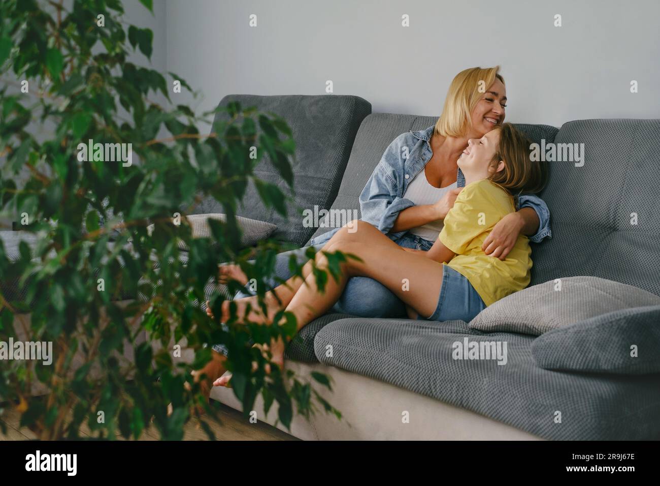 Young loving mother hugging her teenage daughter, mom demonstrating unconditional love for child ...