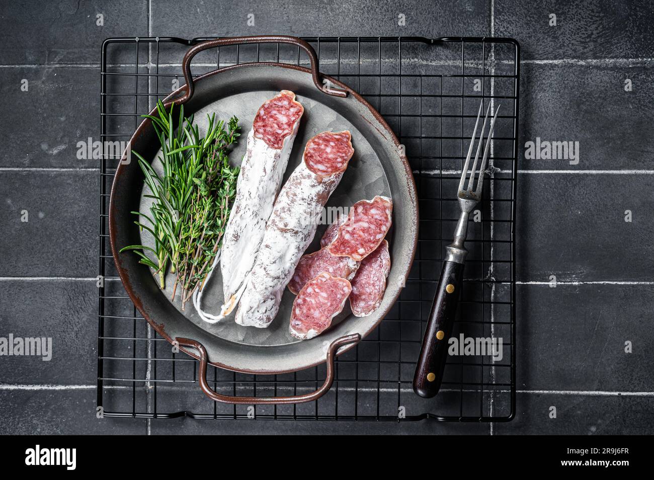 Fuet Salami slices in a steel tray. Traditional Spanish sausage. Black ...