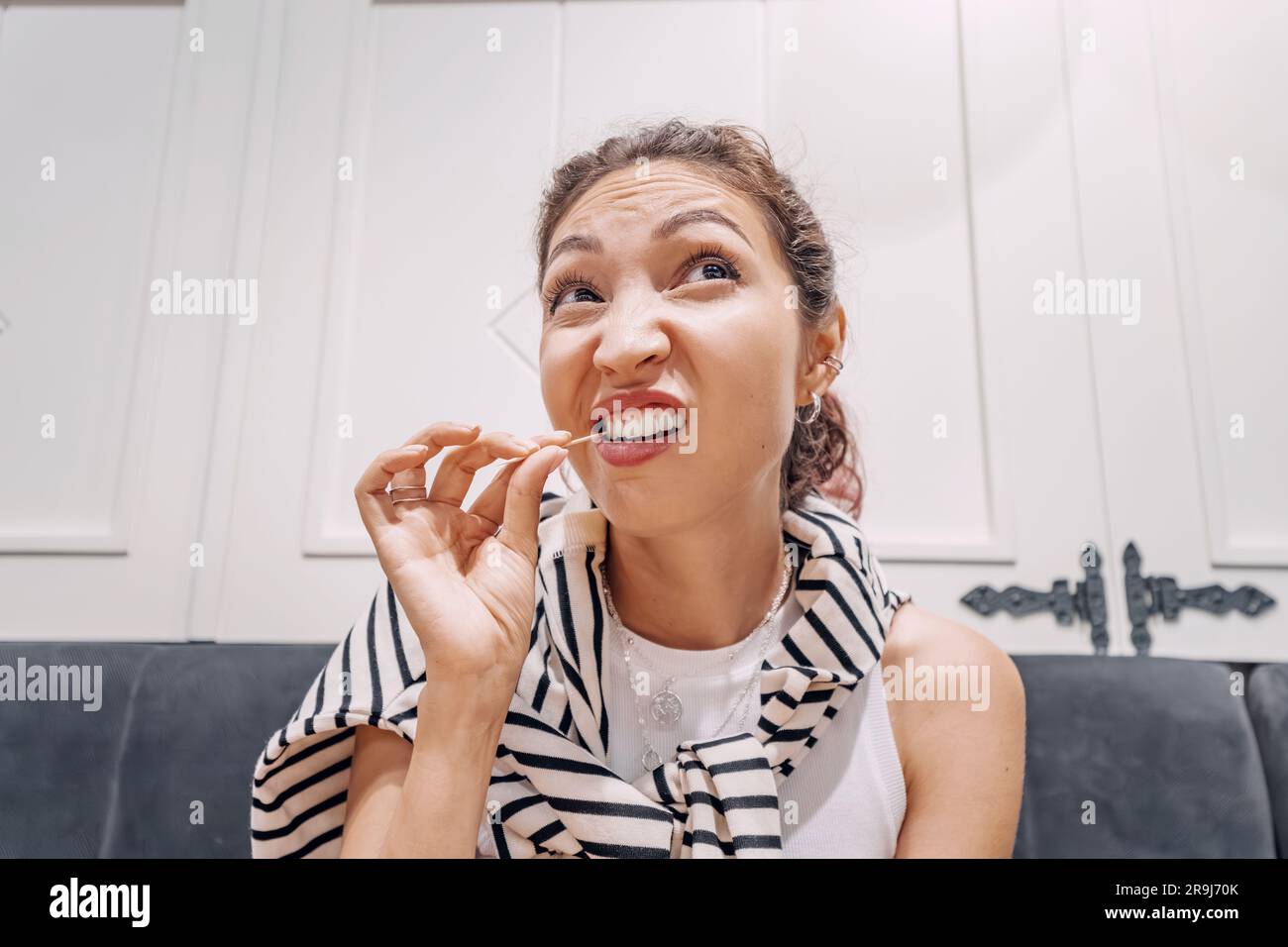 A girl picks her teeth with a toothpick after dinner in a cafe on a ...