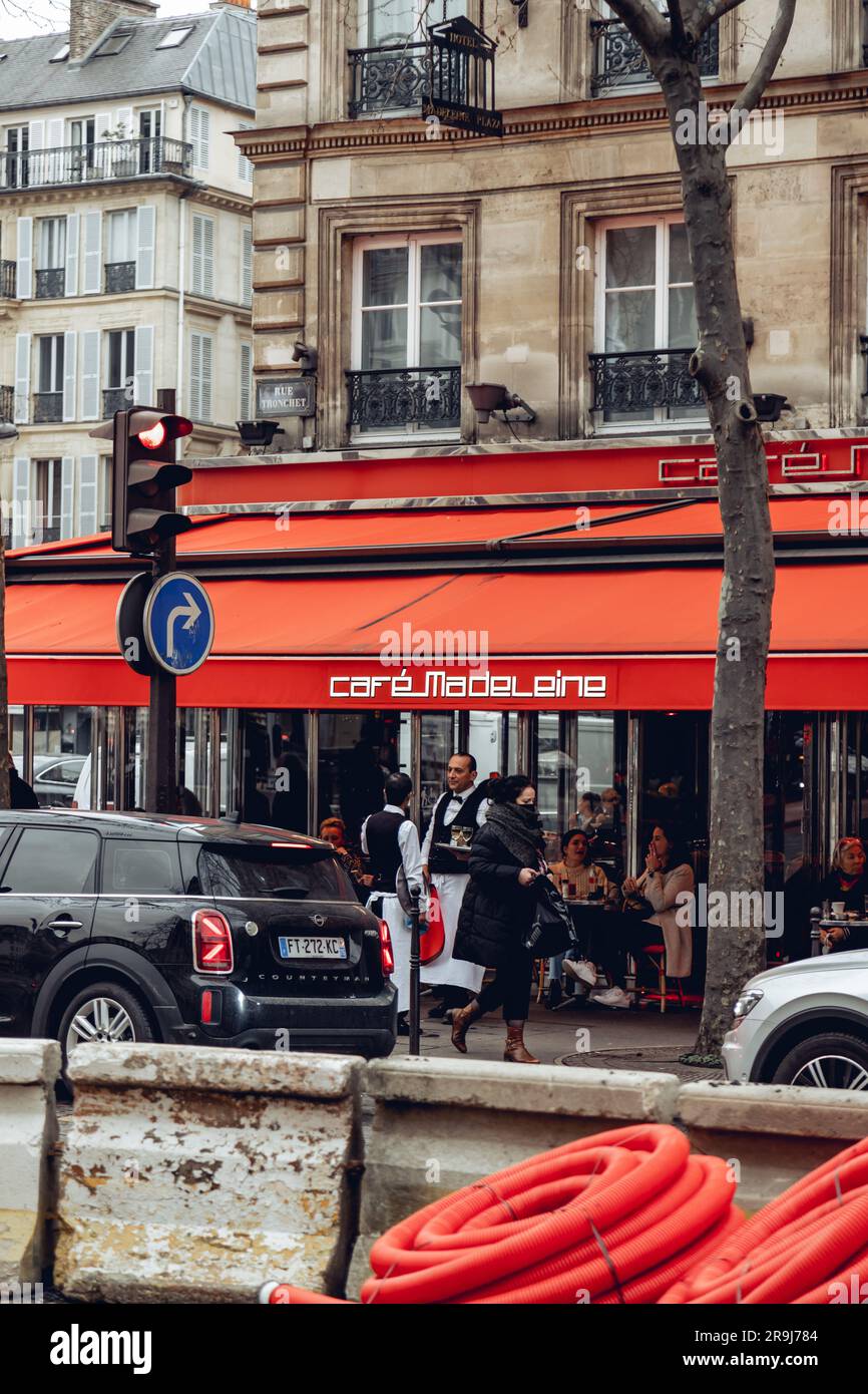 A busy street corner with a sidewalk bustling with pedestrians and cars ...