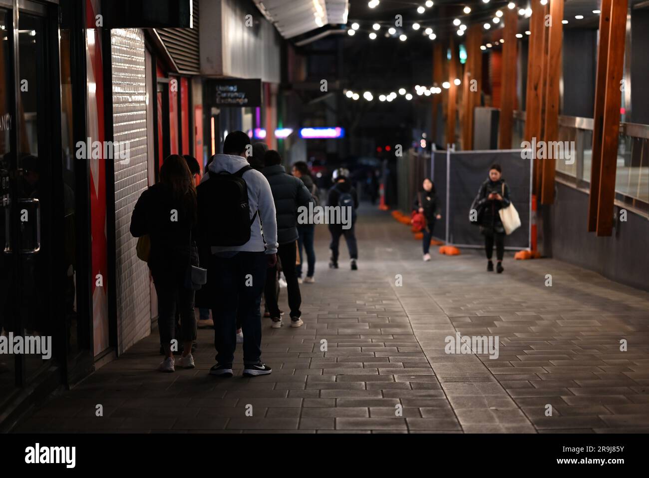 View of the back of a queue, or line, of people outside United Currency ...