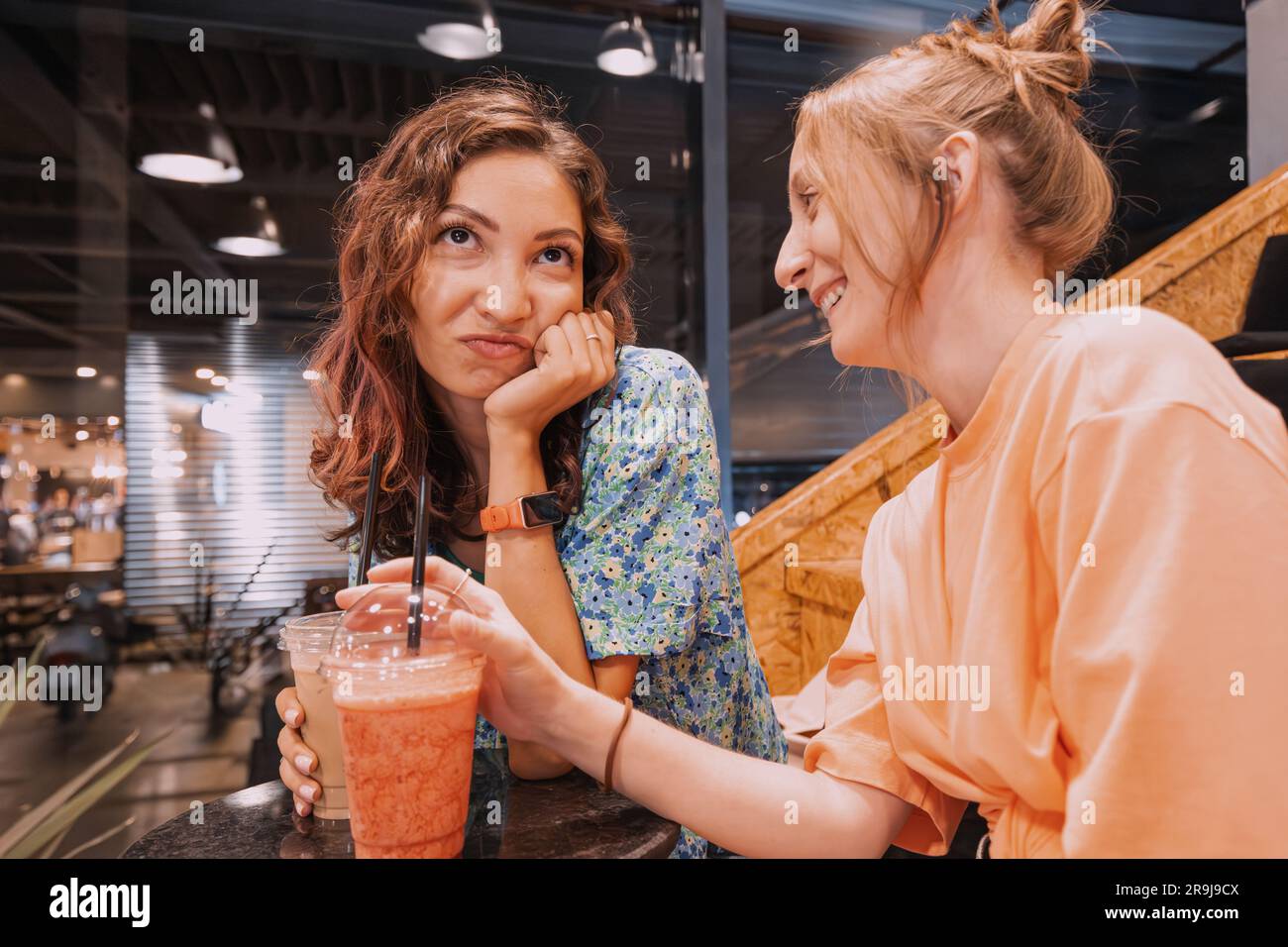 Happy funny girls talking and gossiping in cafe Stock Photo - Alamy