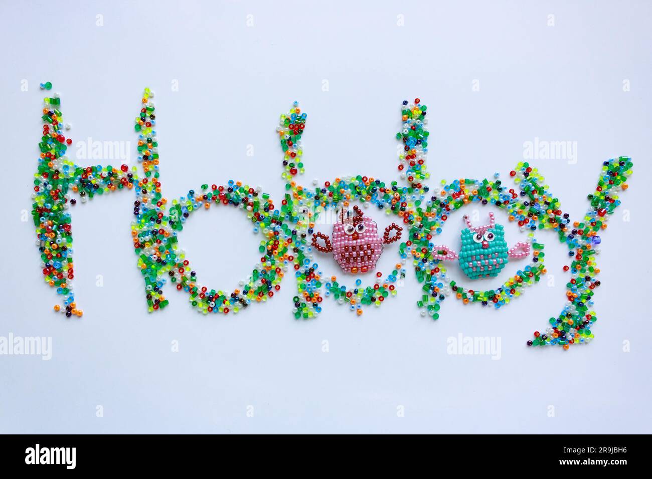 The word Hobby written on a white background with multi-colored beads ...