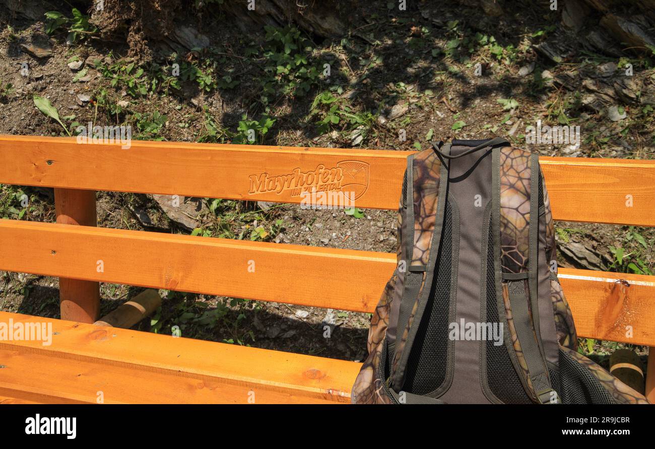 A hiking backpack on a wooden bench with the lettering Mayrhofen im ...