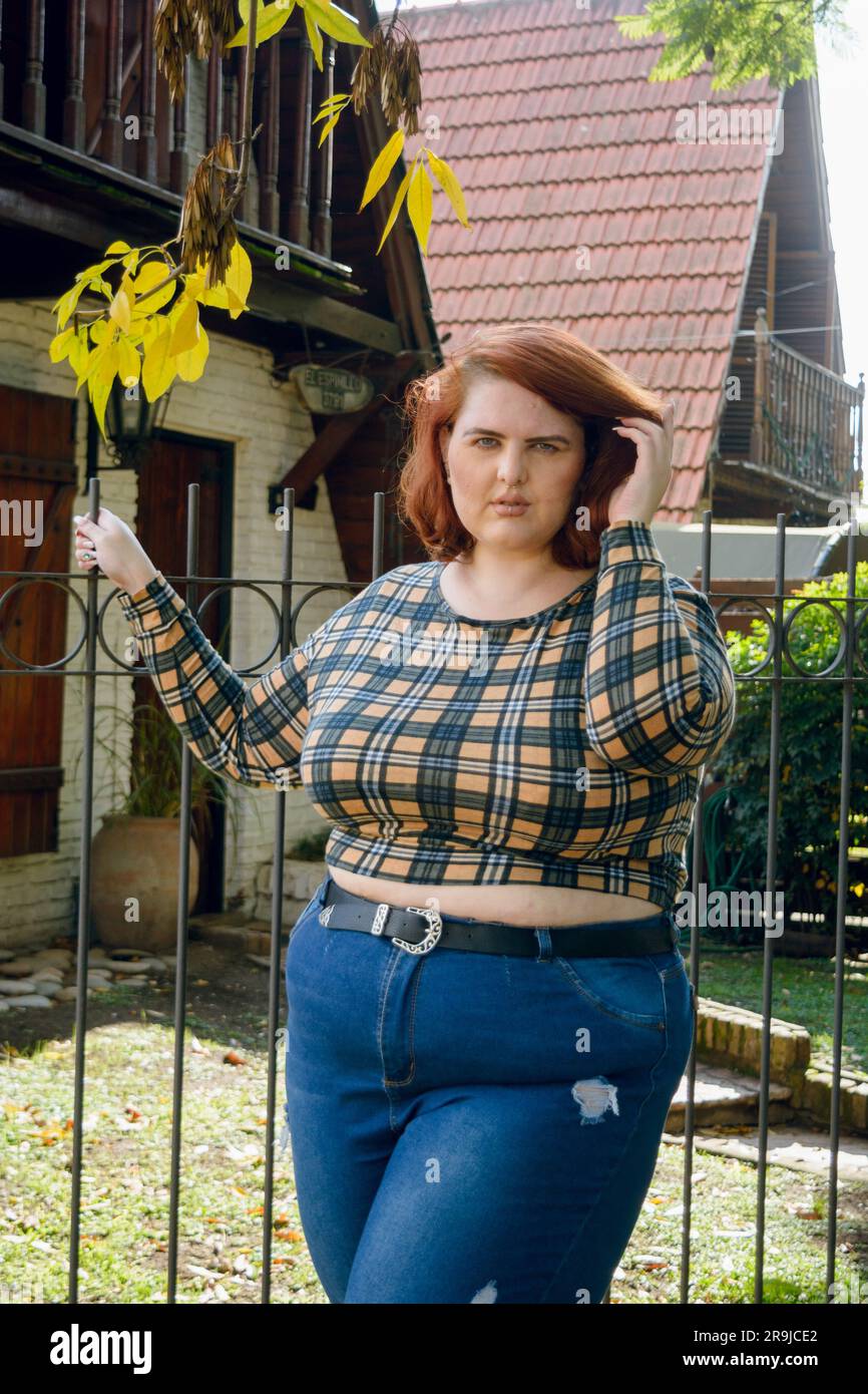 young latina woman of argentinian ethnicity, posing in front of a house ...