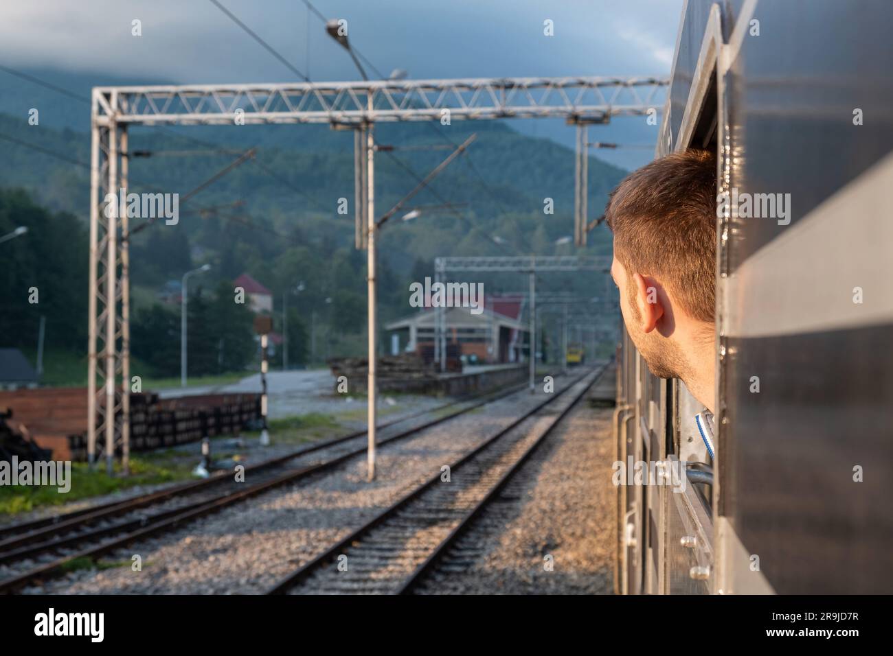 Young man looking out the train window while train arriving to the ...
