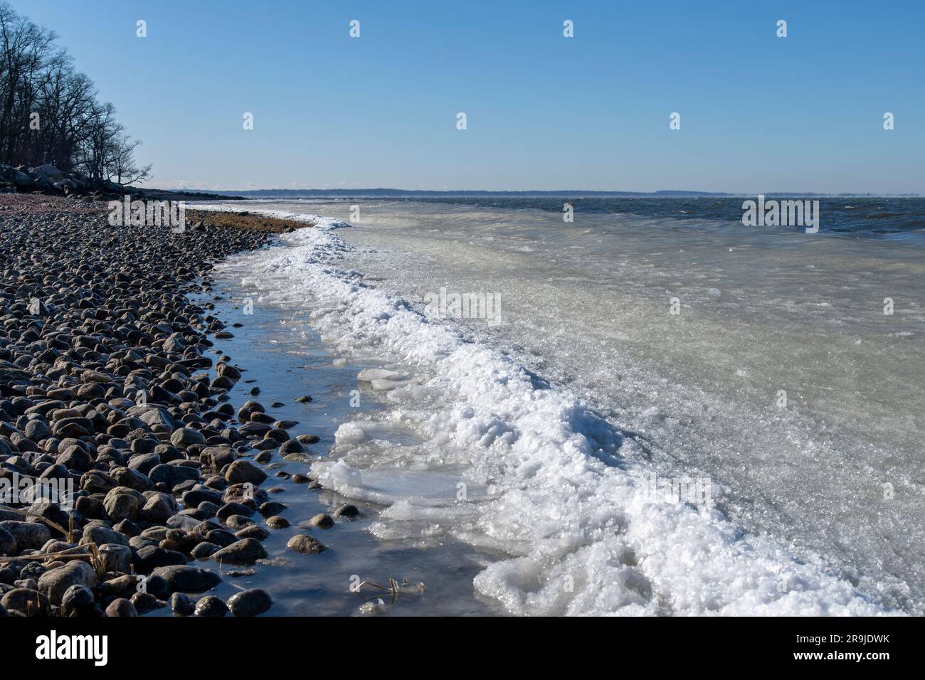 Low angle view of icy, slurpee or slush waves on pebble beach Greenwich ...