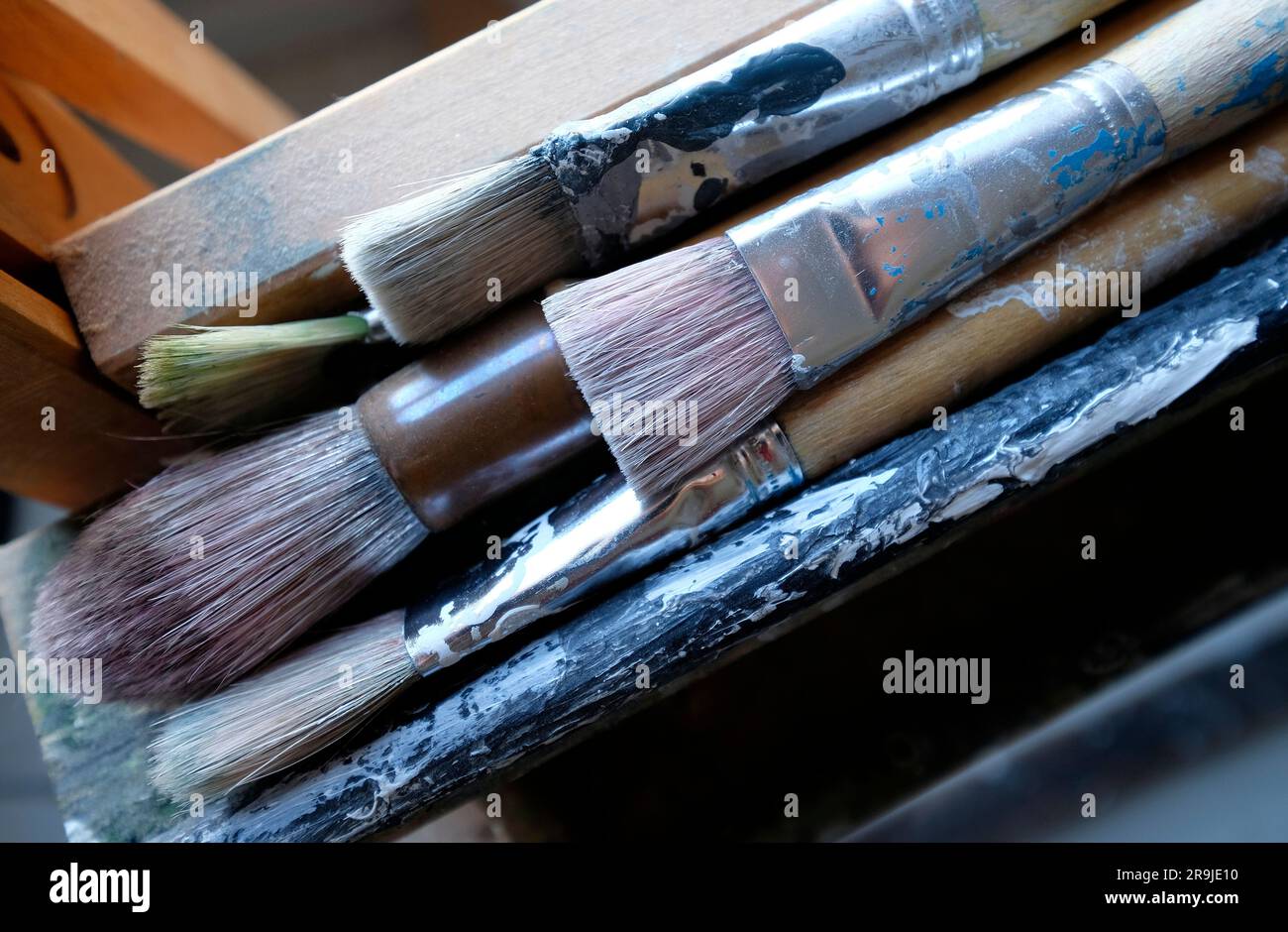 artist paint brushes on easel Stock Photo - Alamy