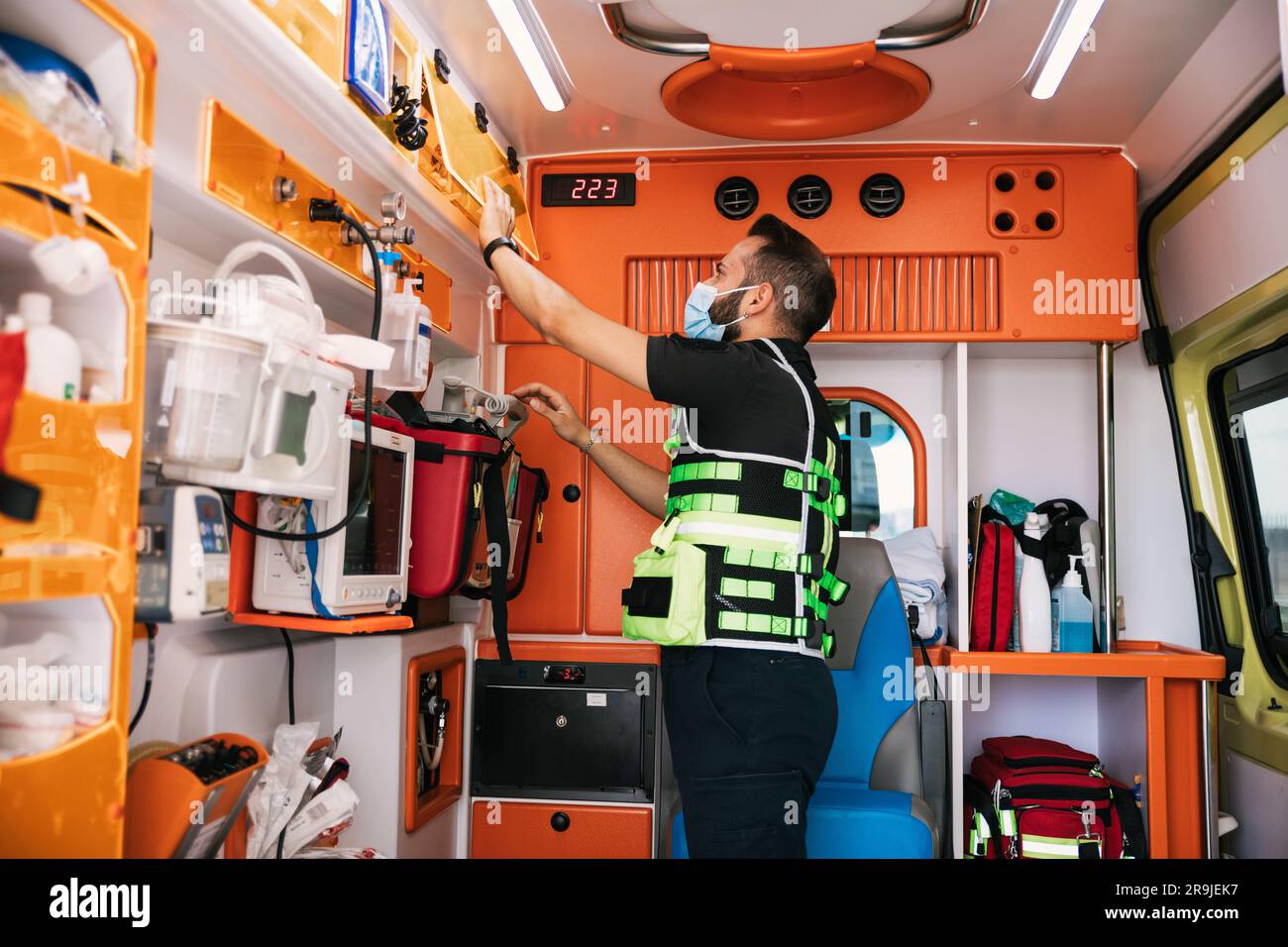 Side view of paramedic in uniform focusing while standing in modern ...