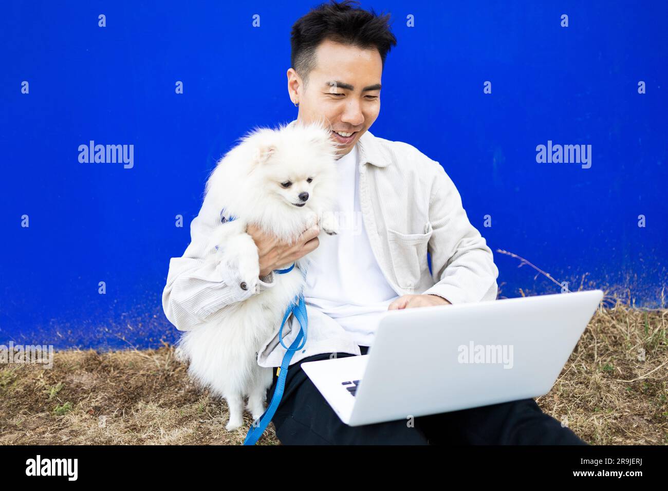 Happy Asian male dog owner in casual wear with cute Pomeranian Spitz ...