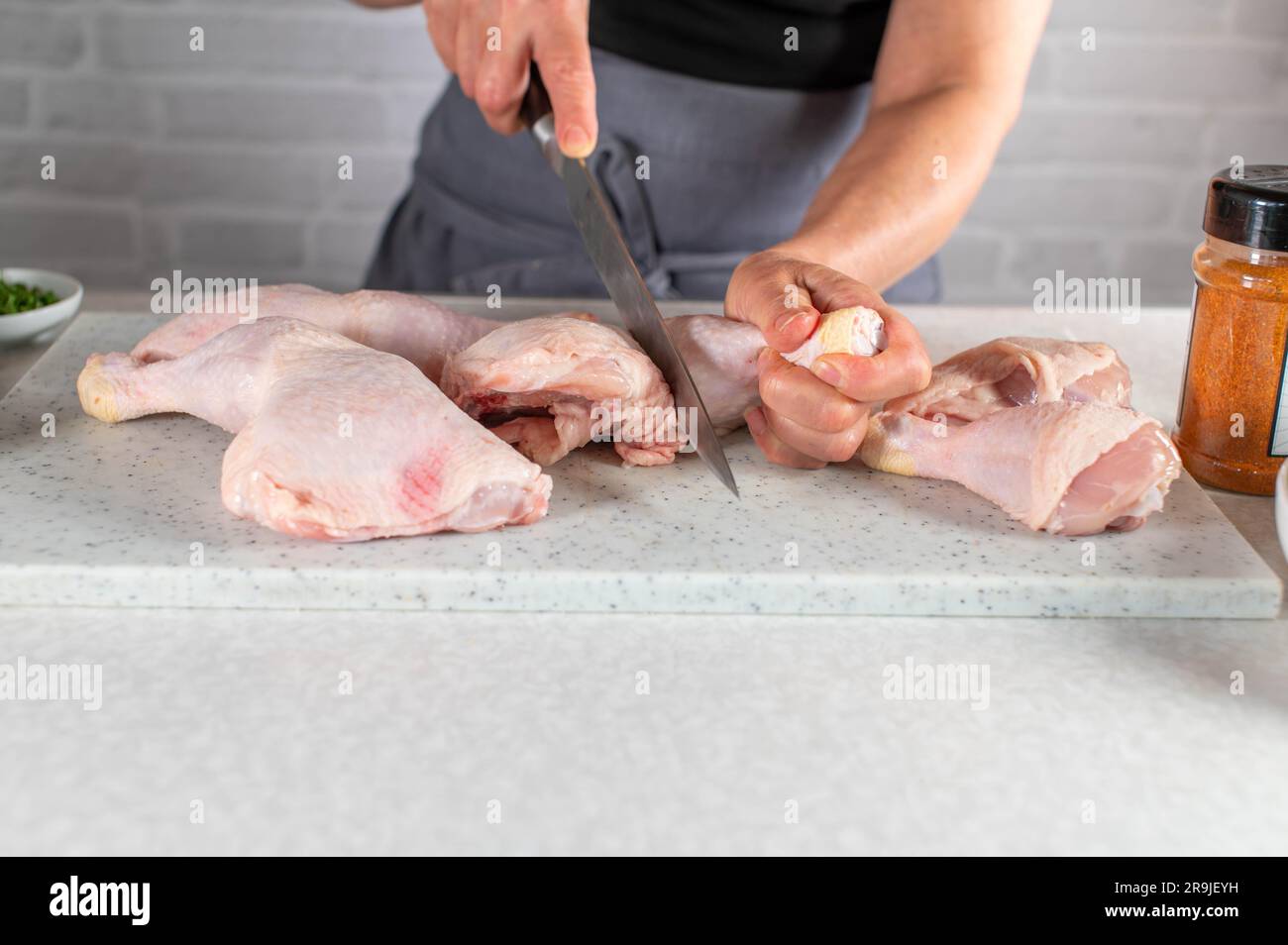 Cutting or carving raw chicken leg into shank and drumstick. Part of a ...