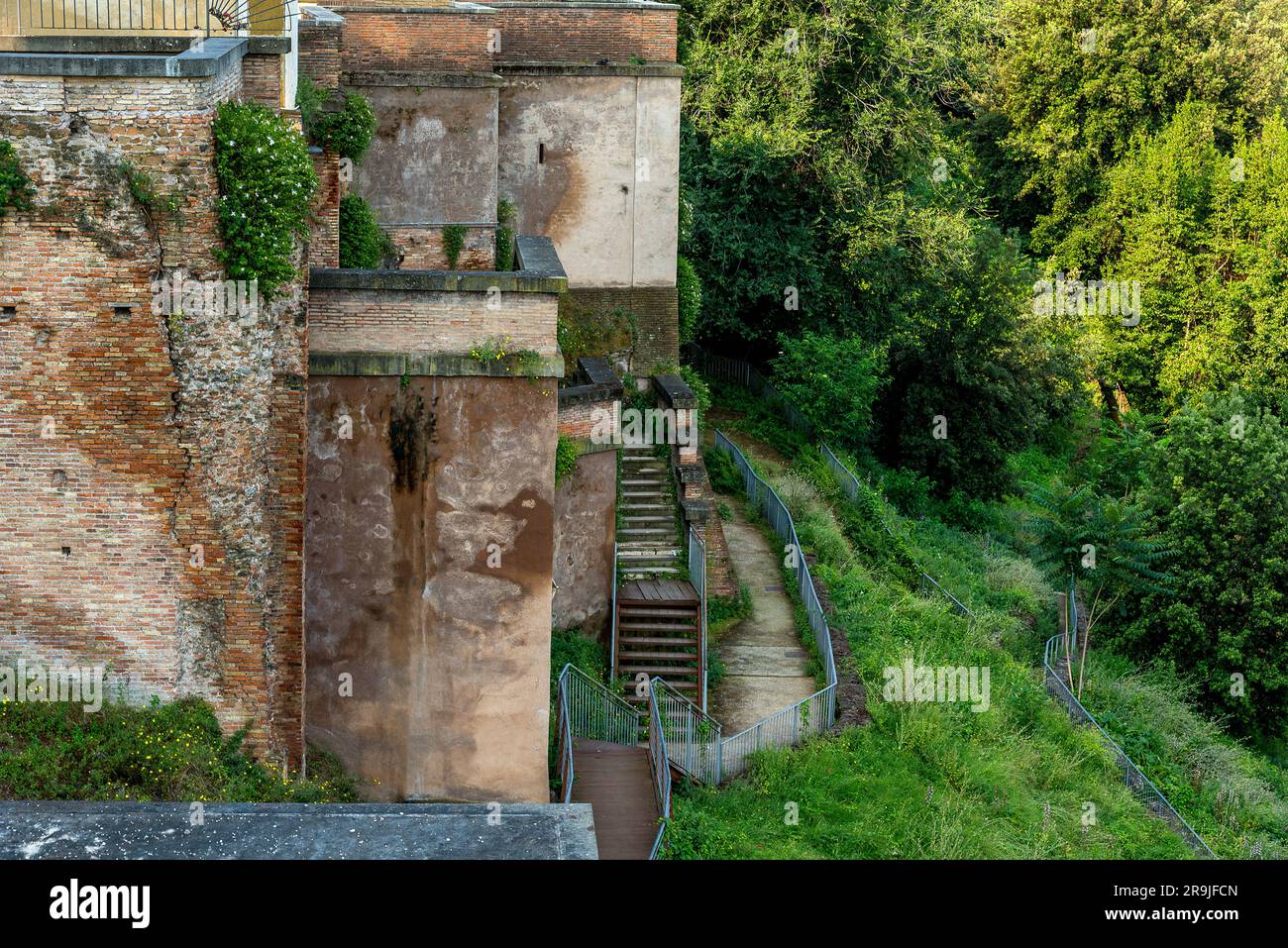 Historic wall in old ancient Rome with stairs and flowers and trees ...