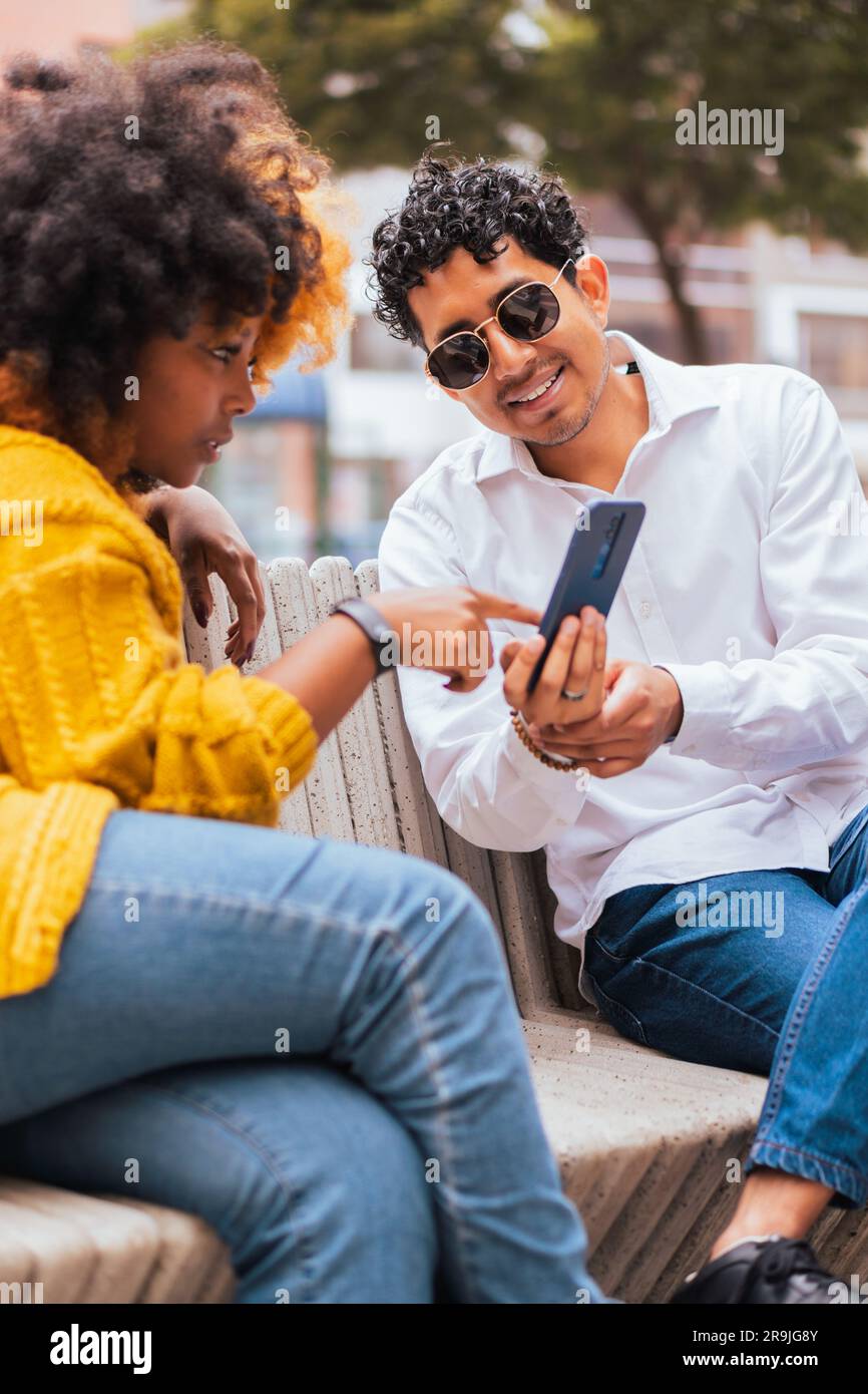 Happy black female with Afro yellow hair in casual clothes smiling and looking at screen with ...