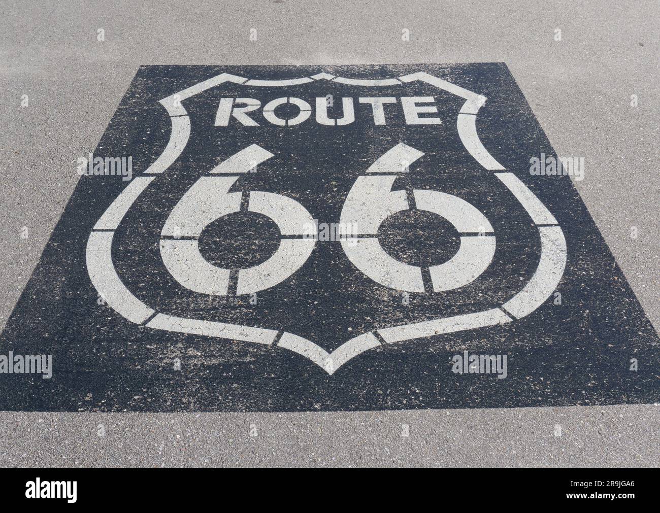 A vintage Route 66 highway sign painted on an asphalt highway in a ...