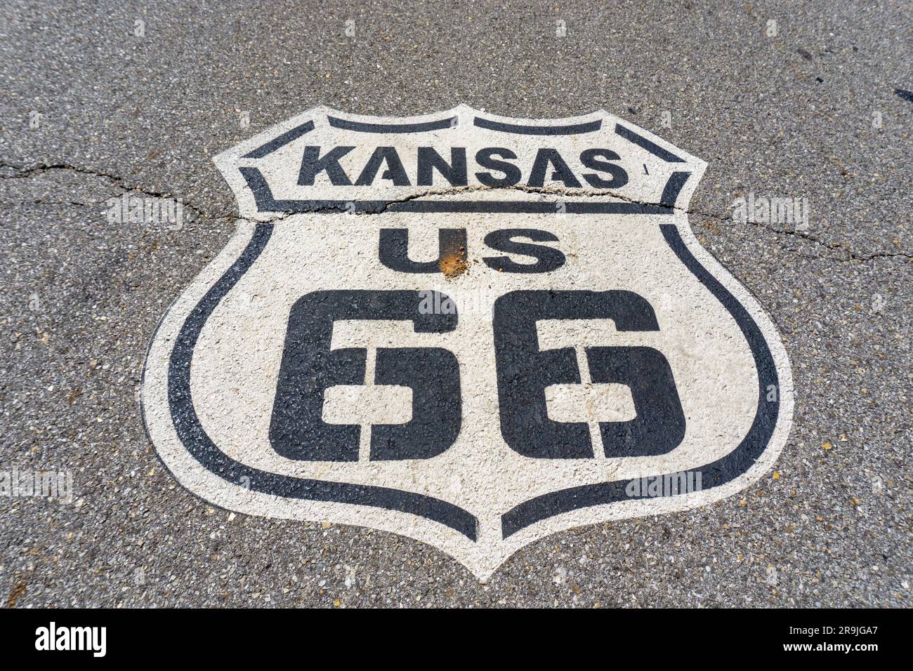 A vintage Kansas 66 highway sign painted on an asphalt highway in a ...