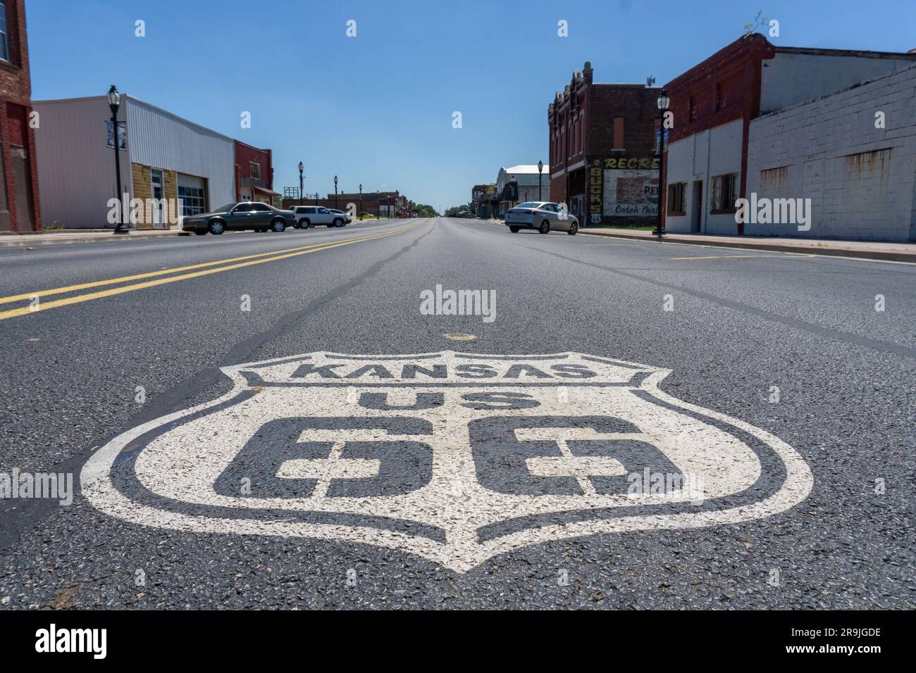 A vintage Kansas 66 highway sign painted on an asphalt highway in a ...