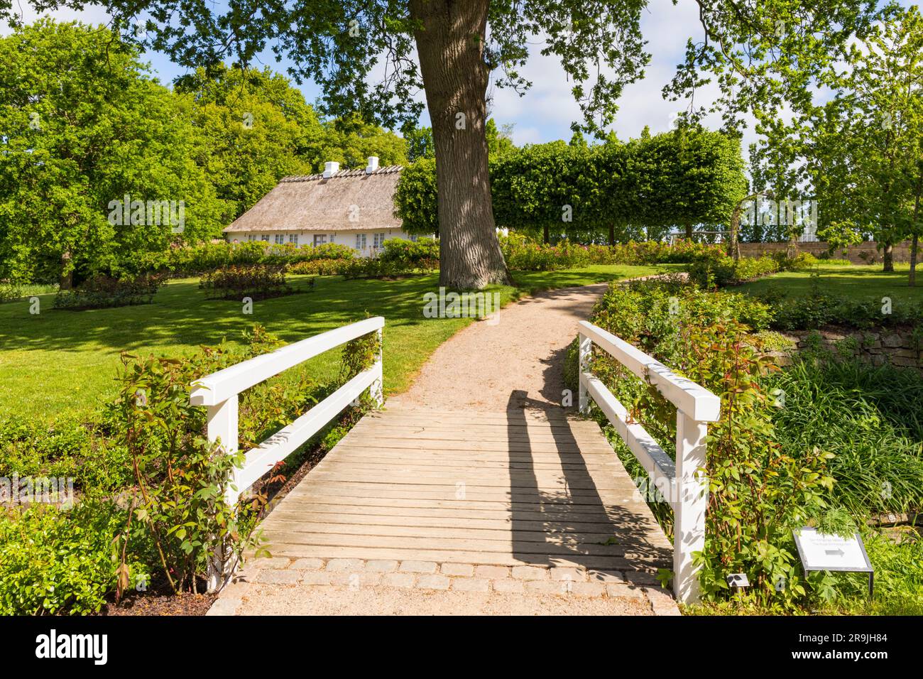 Bridge and thatched roof building at the public park of Gråsten Palace ...