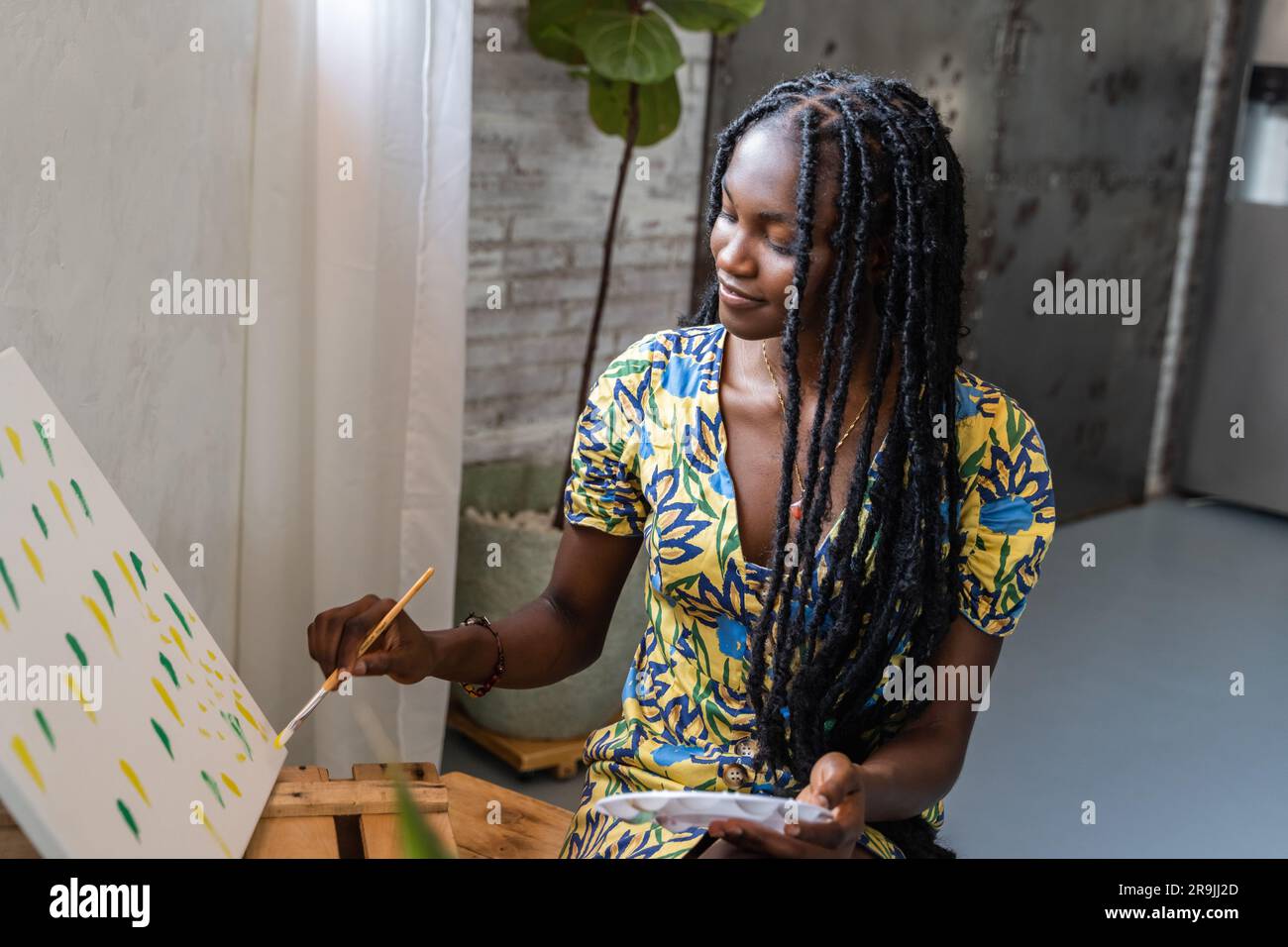 Positive young African American female artist in casual clothes with ...